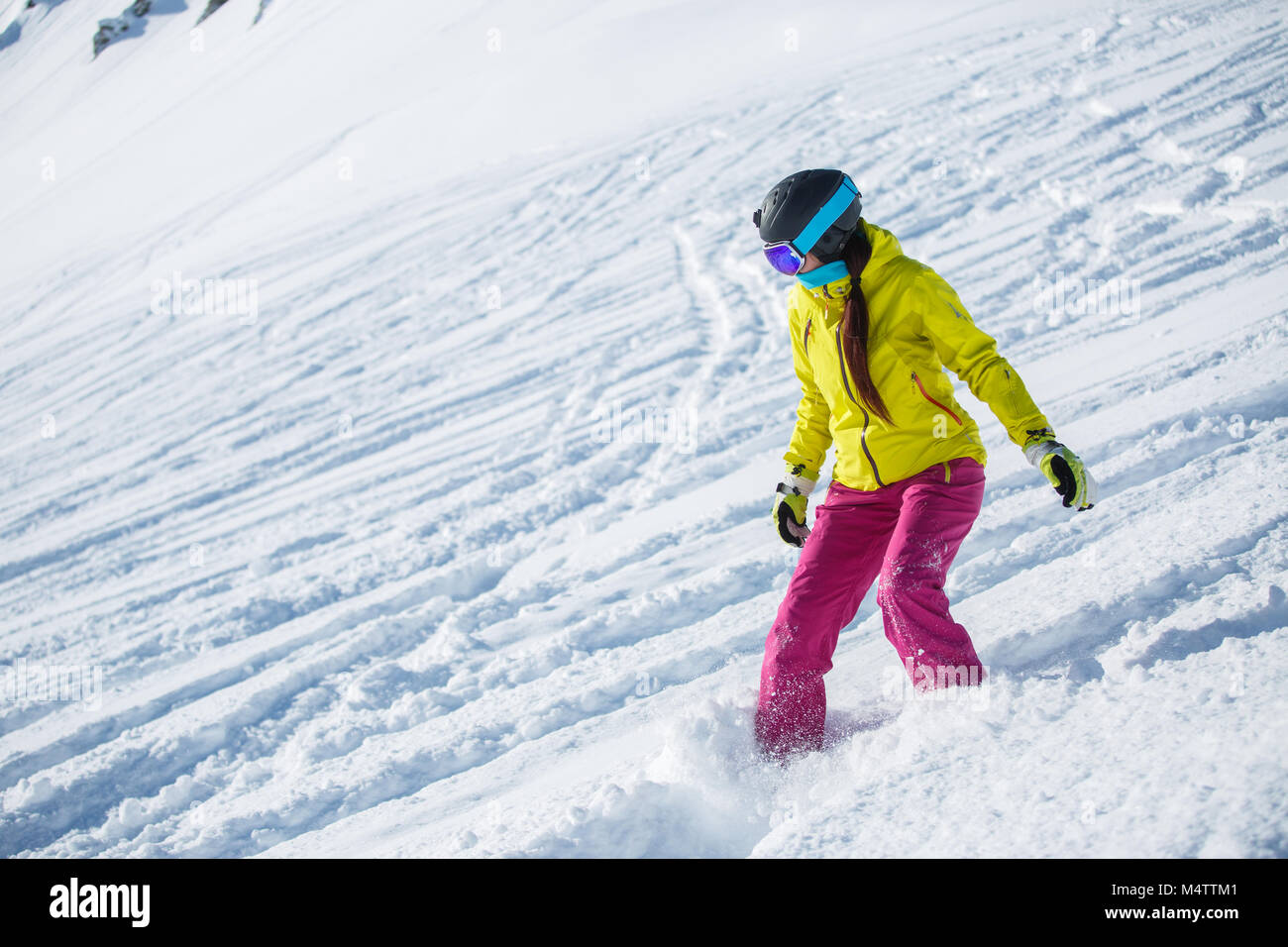 Image of brunette athlete wearing helmet and mask, snowboarding from ...