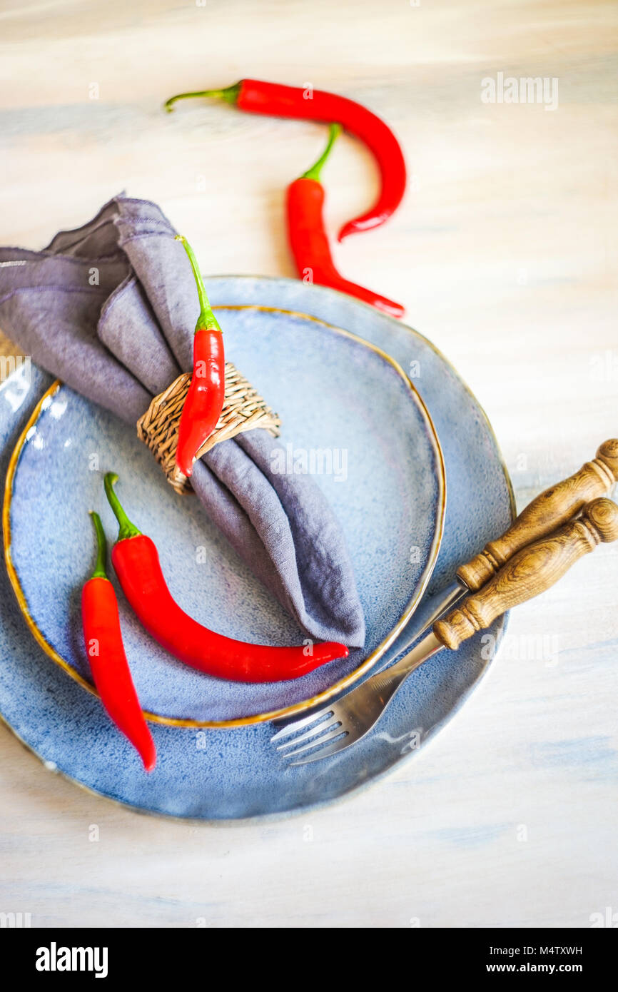 Table setting with red hot chili pepper on dark wooden table with copy ...