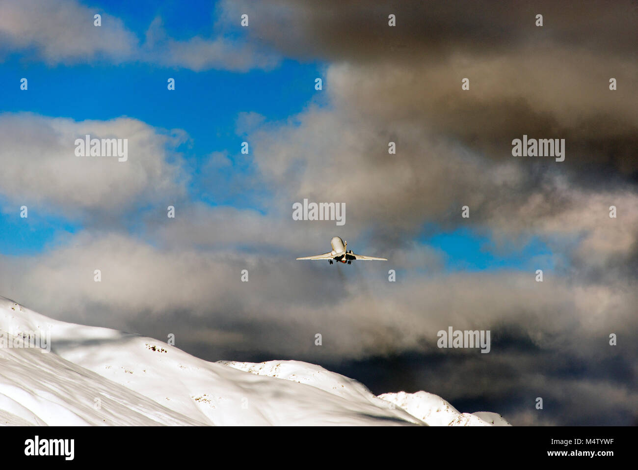 A private jet up in the air taking off in the cloudy blue sky in the ...