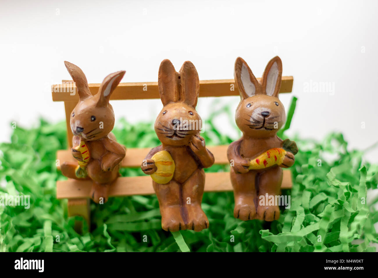 decoration rabbits sitting on a bench near a window Stock Photo - Alamy