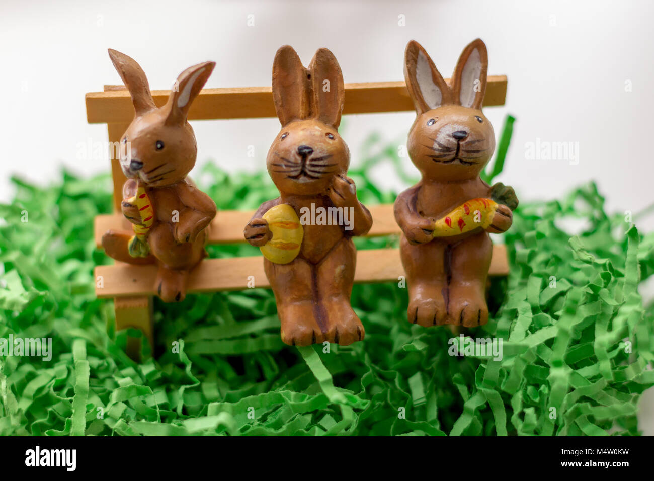 decoration rabbits sitting on a bench near a window Stock Photo - Alamy
