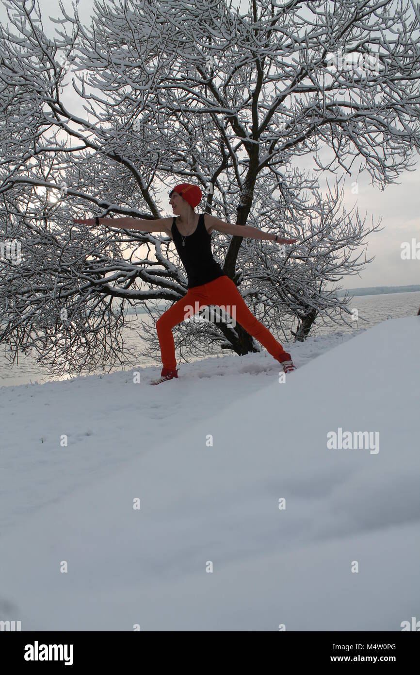 beautiful flexible young woman made yoga morning poses in cold winter ...