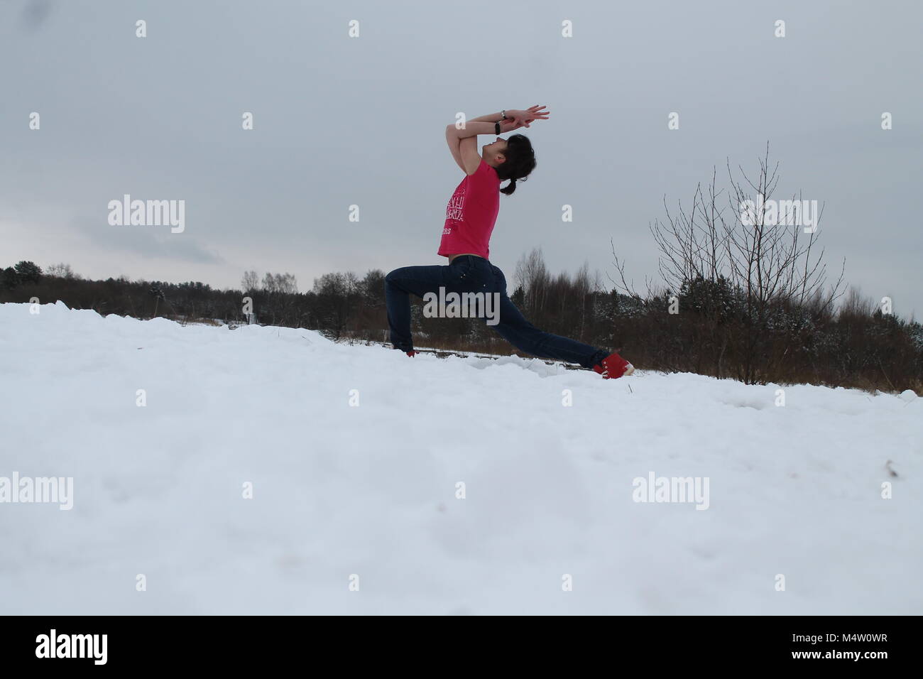 beautiful flexible young woman made yoga morning poses in cold winter ...