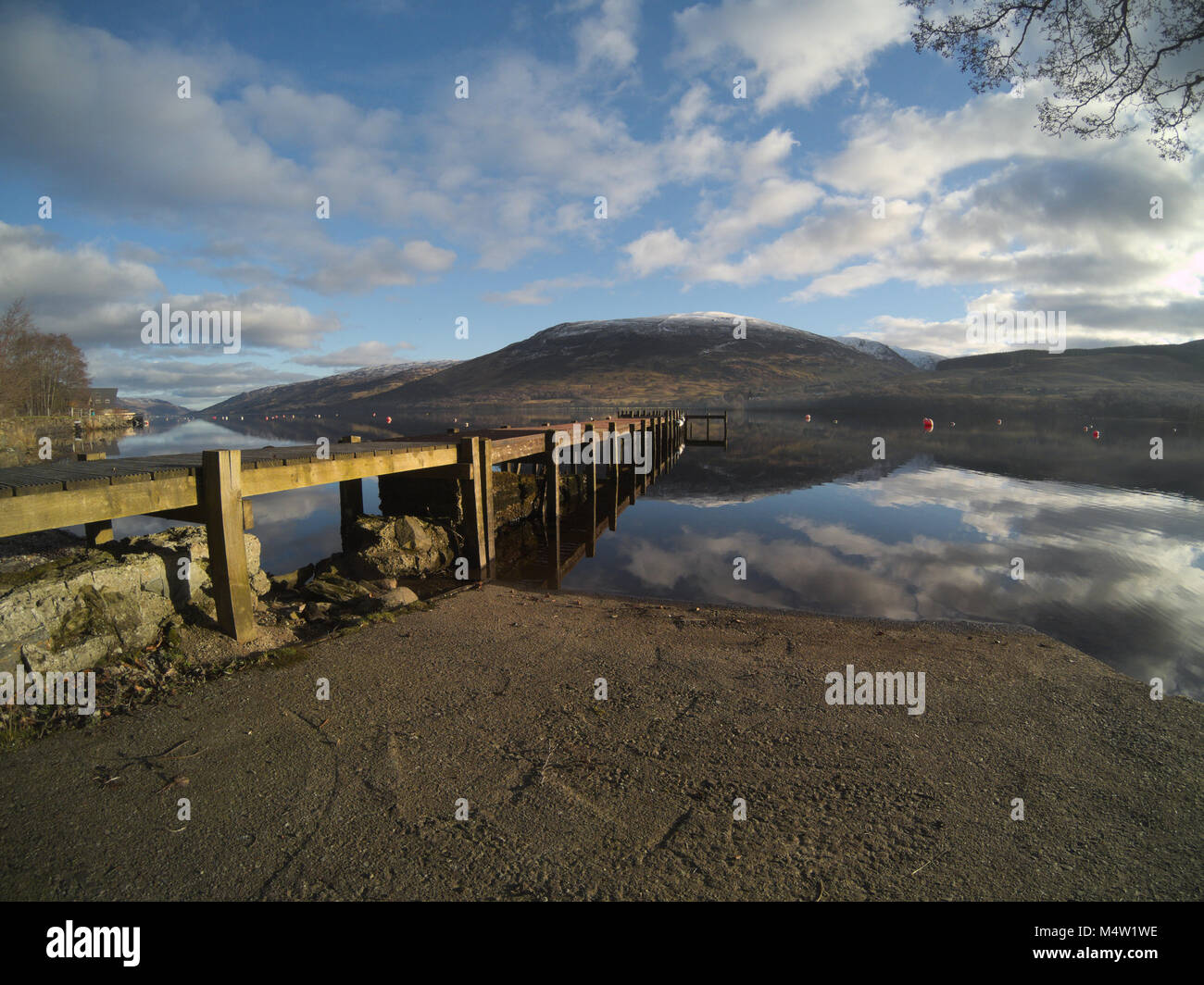 Peaceful lake scene showing nice reflections of sky and small jetty at ...