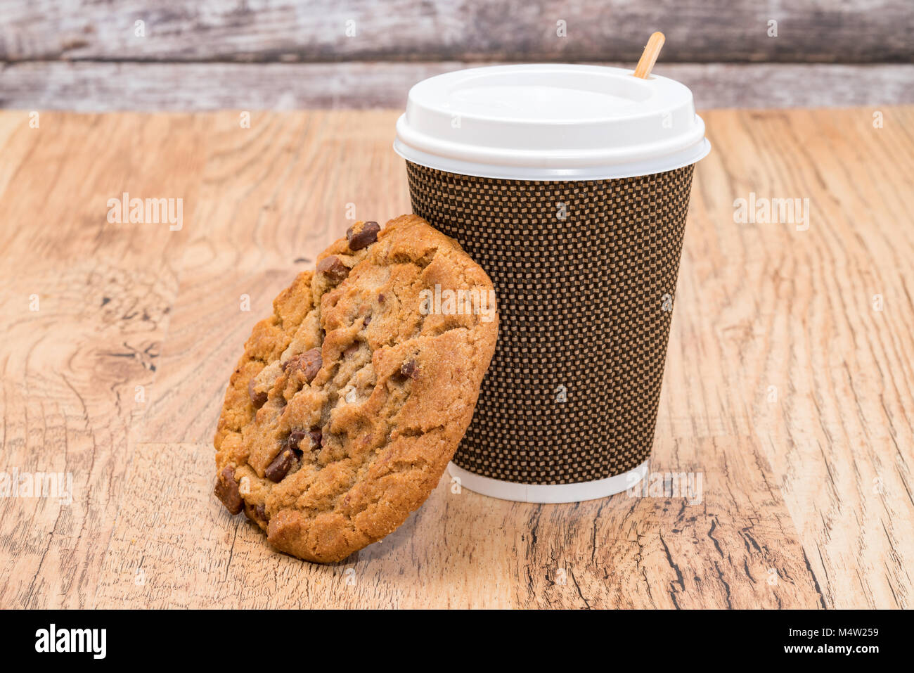 Take out coffee and a chocolate chip cookie biscuit Stock Photo - Alamy
