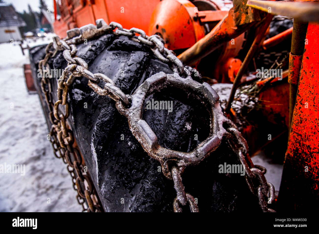 Logging machine giant wheels equipped with snow chains. Winter concept ...