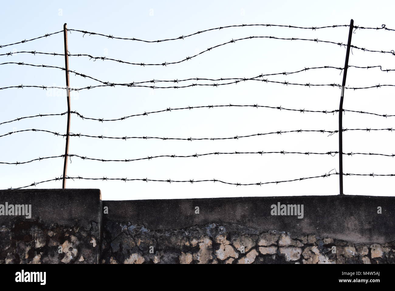 Wall with barbed wire Stock Photo - Alamy
