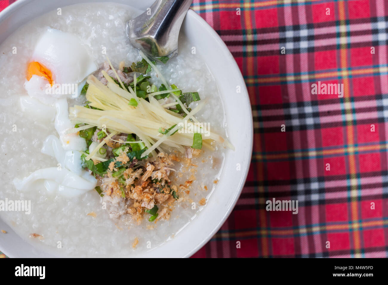 Rice porridge pork minced egg in bowl with tartan pattern background ...