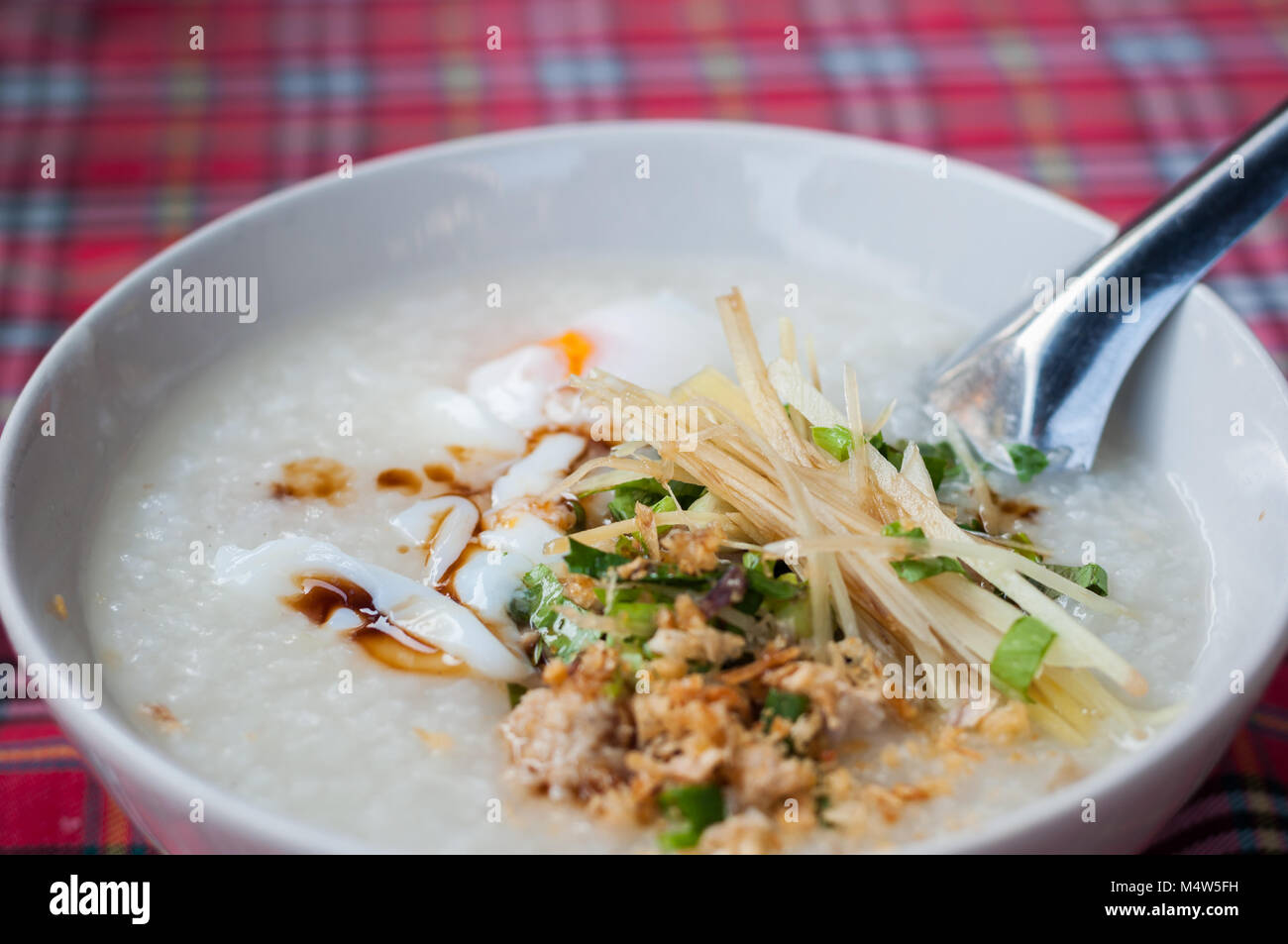 Rice porridge pork minced egg in bowl with tartan pattern background ...