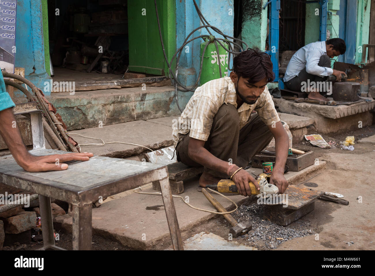 Men grinding metal at a shop in Varanasi, India Stock Photo - Alamy