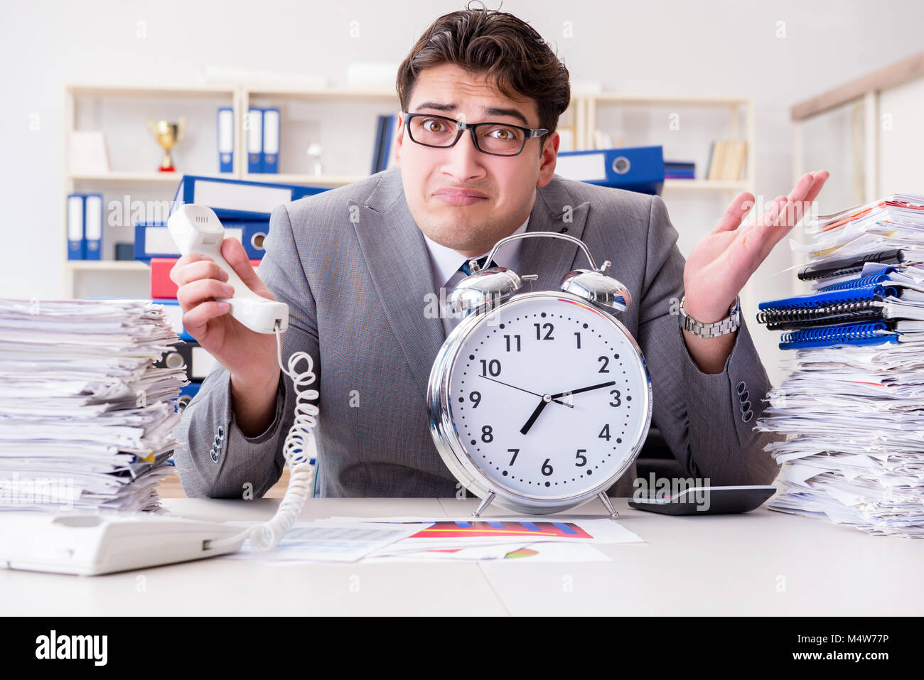 Businessman missing deadlines due to excessive work Stock Photo - Alamy