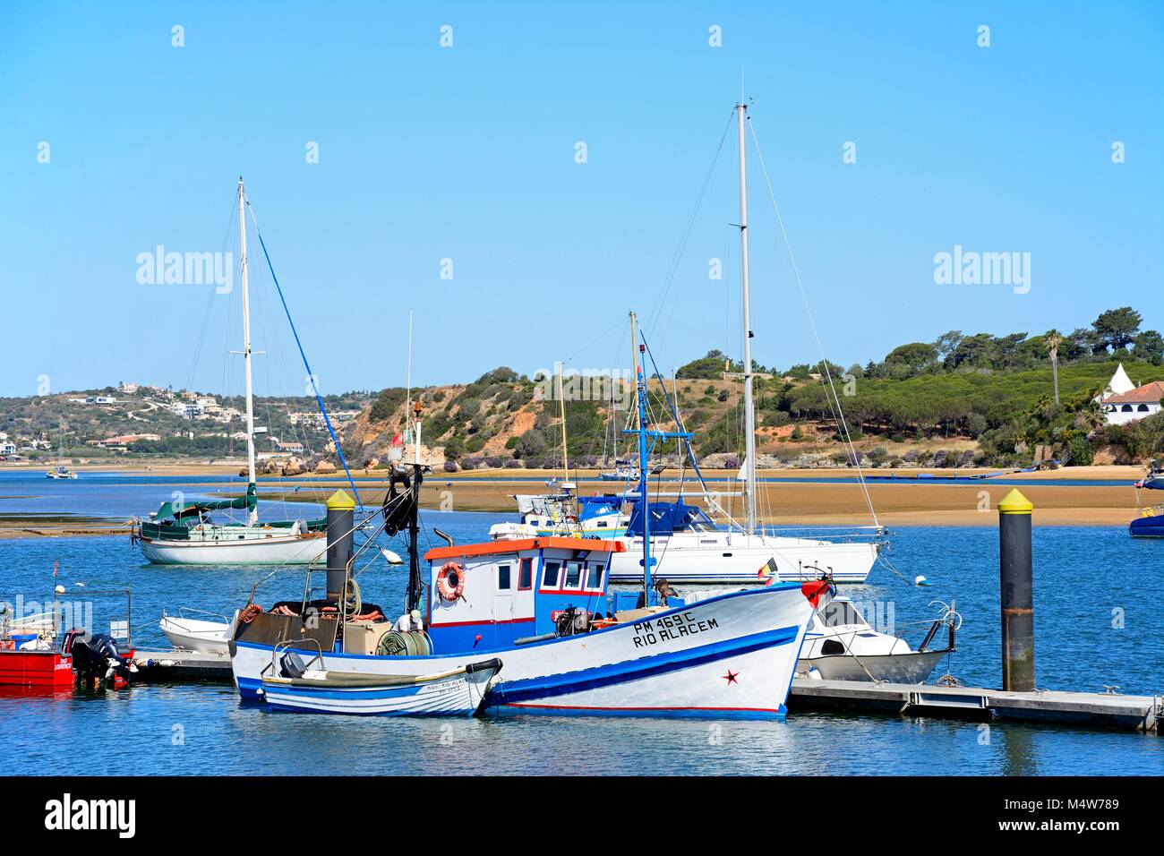 Fishing boats and yachts moored in the estuary, Alvor, Algarve ...