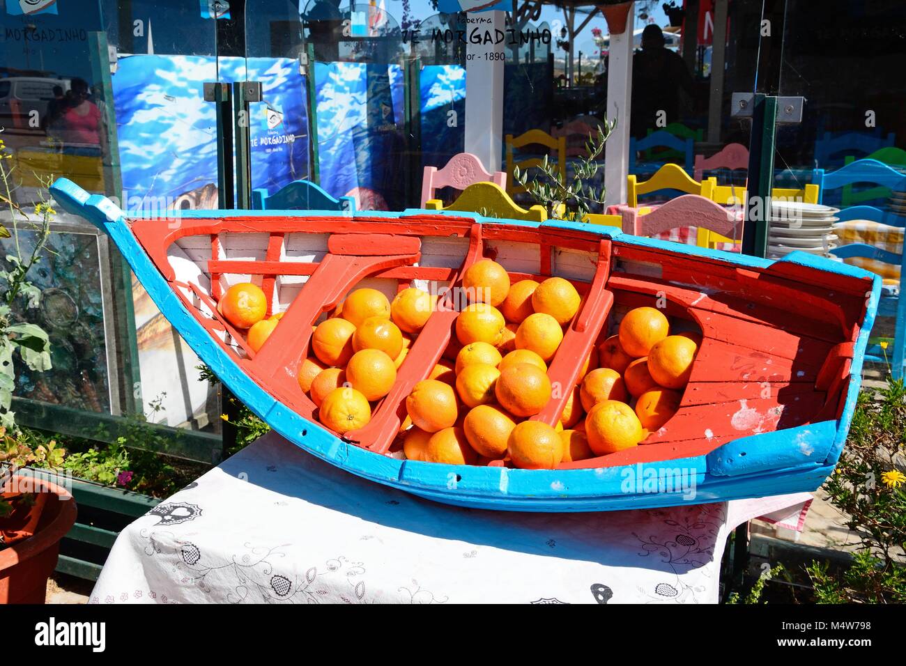 Wooden boat full of oranges at a waterfront restaurant, Alvor, Algarve ...