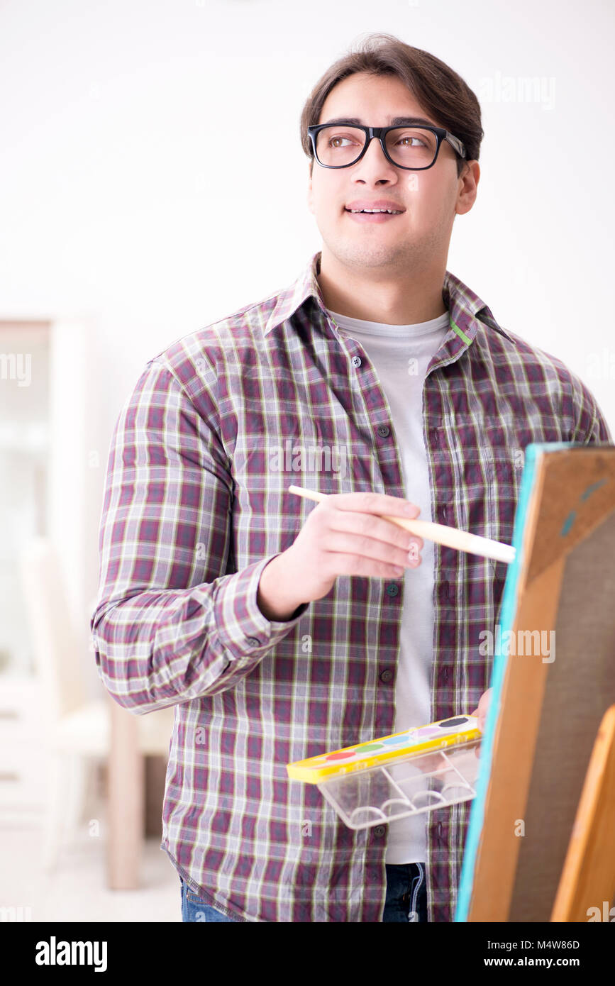 Young male artist drawing pictures in bright studio Stock Photo - Alamy