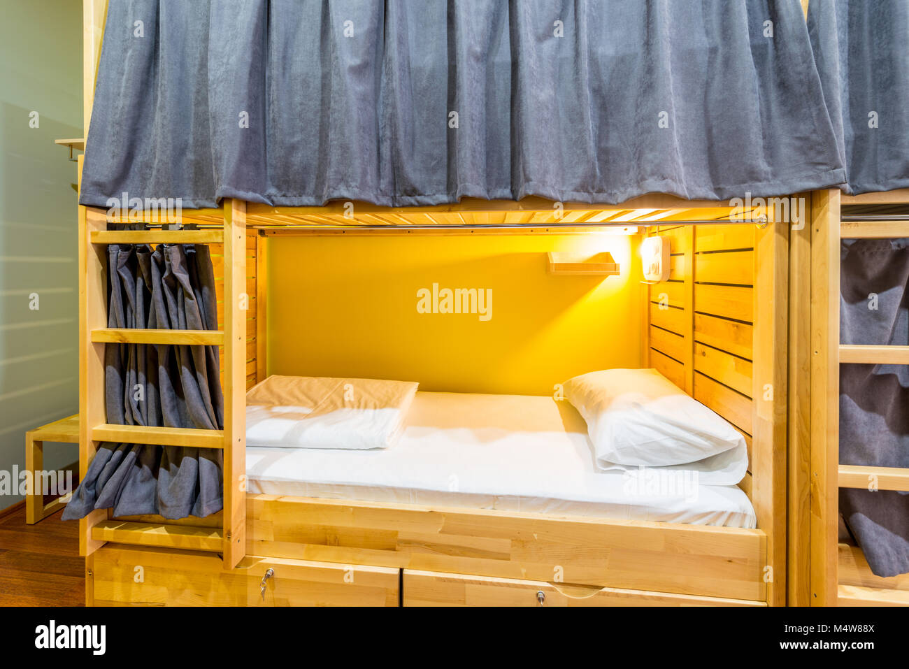 Hostel dormitory beds arranged in room Stock Photo - Alamy