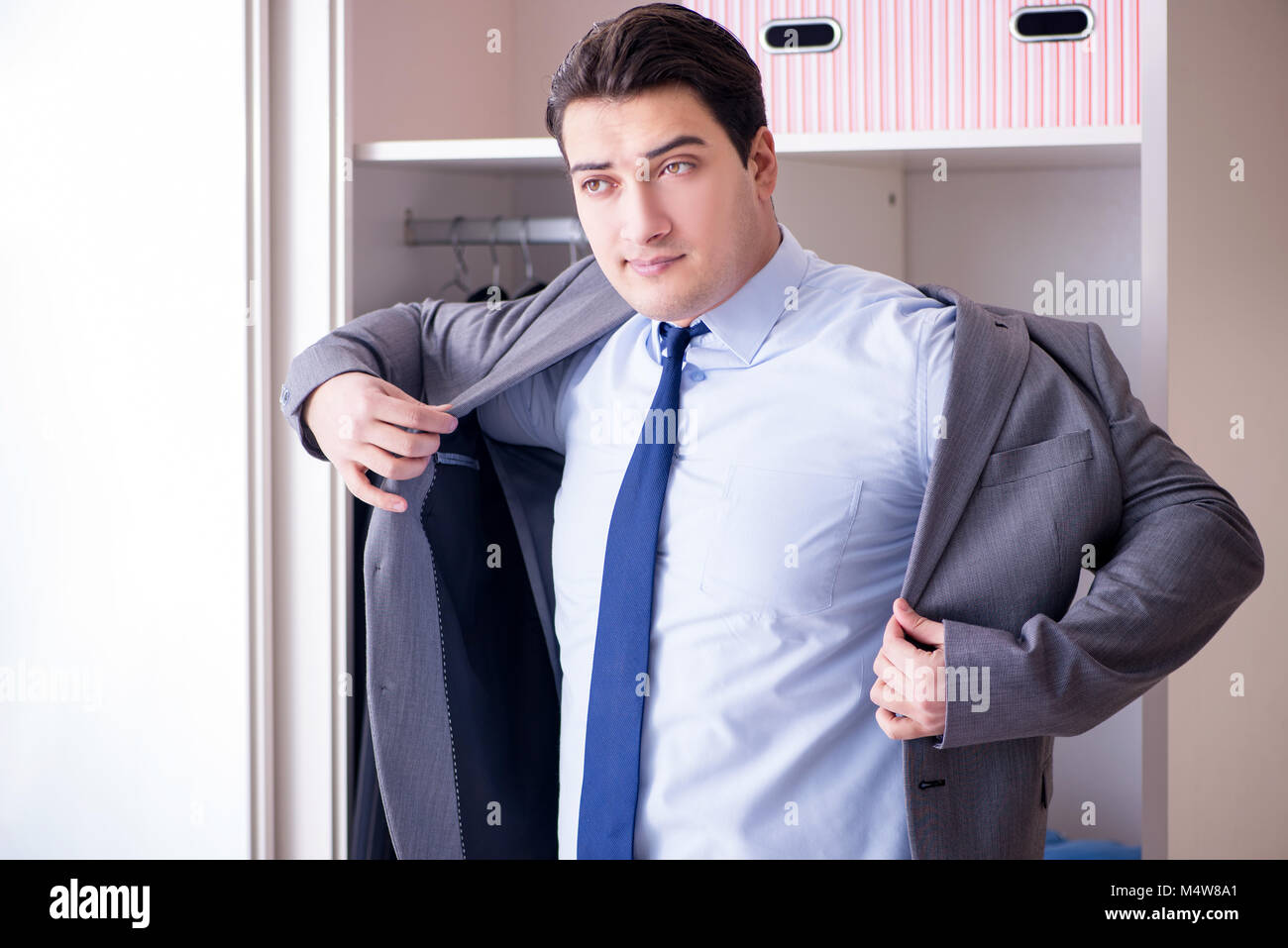 Young man businessman getting dressed for work Stock Photo - Alamy