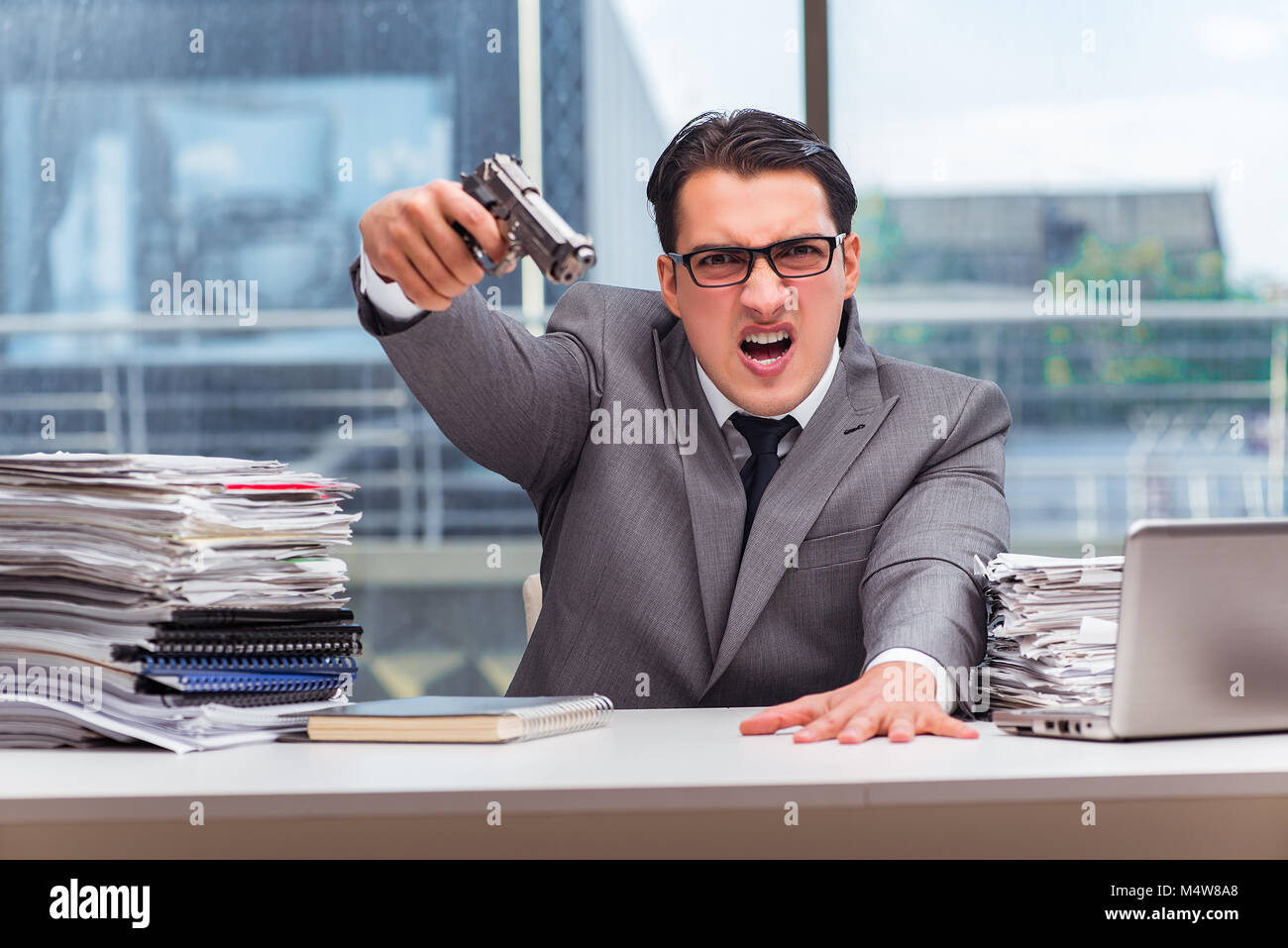 Angry businessman with gun in the office Stock Photo - Alamy