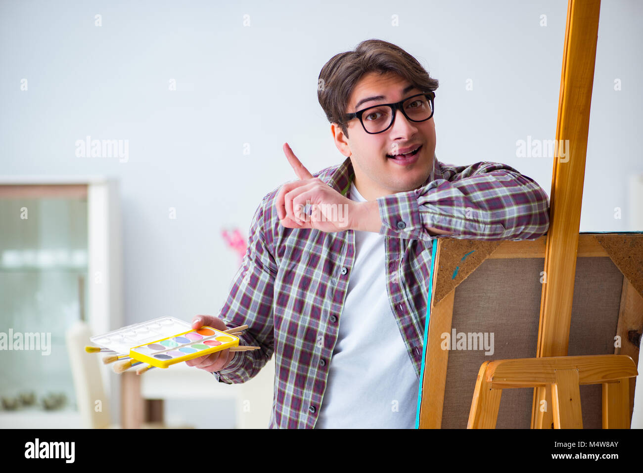 Young male artist drawing pictures in studio Stock Photo - Alamy