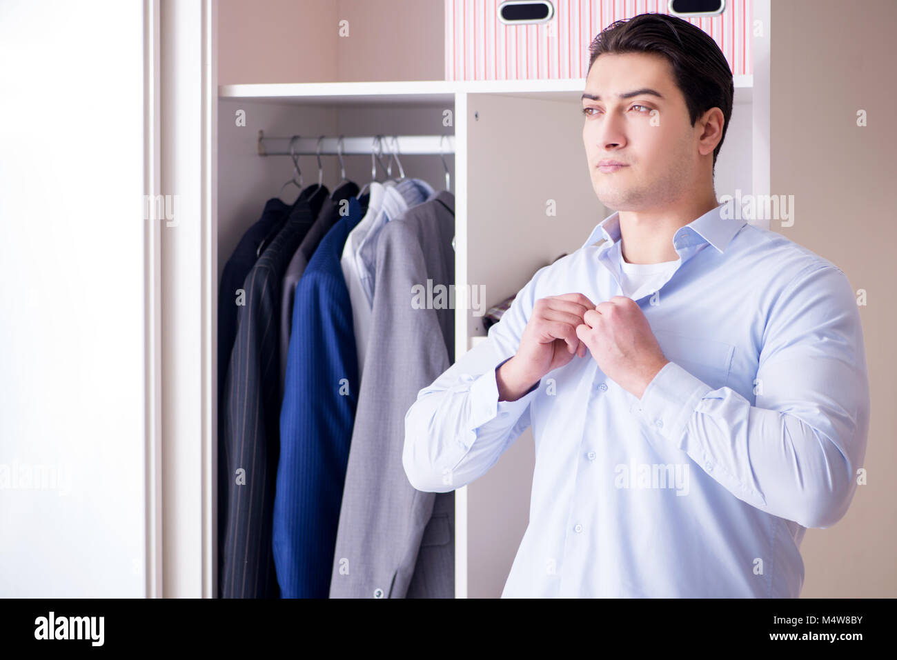 Young man businessman getting dressed for work Stock Photo - Alamy