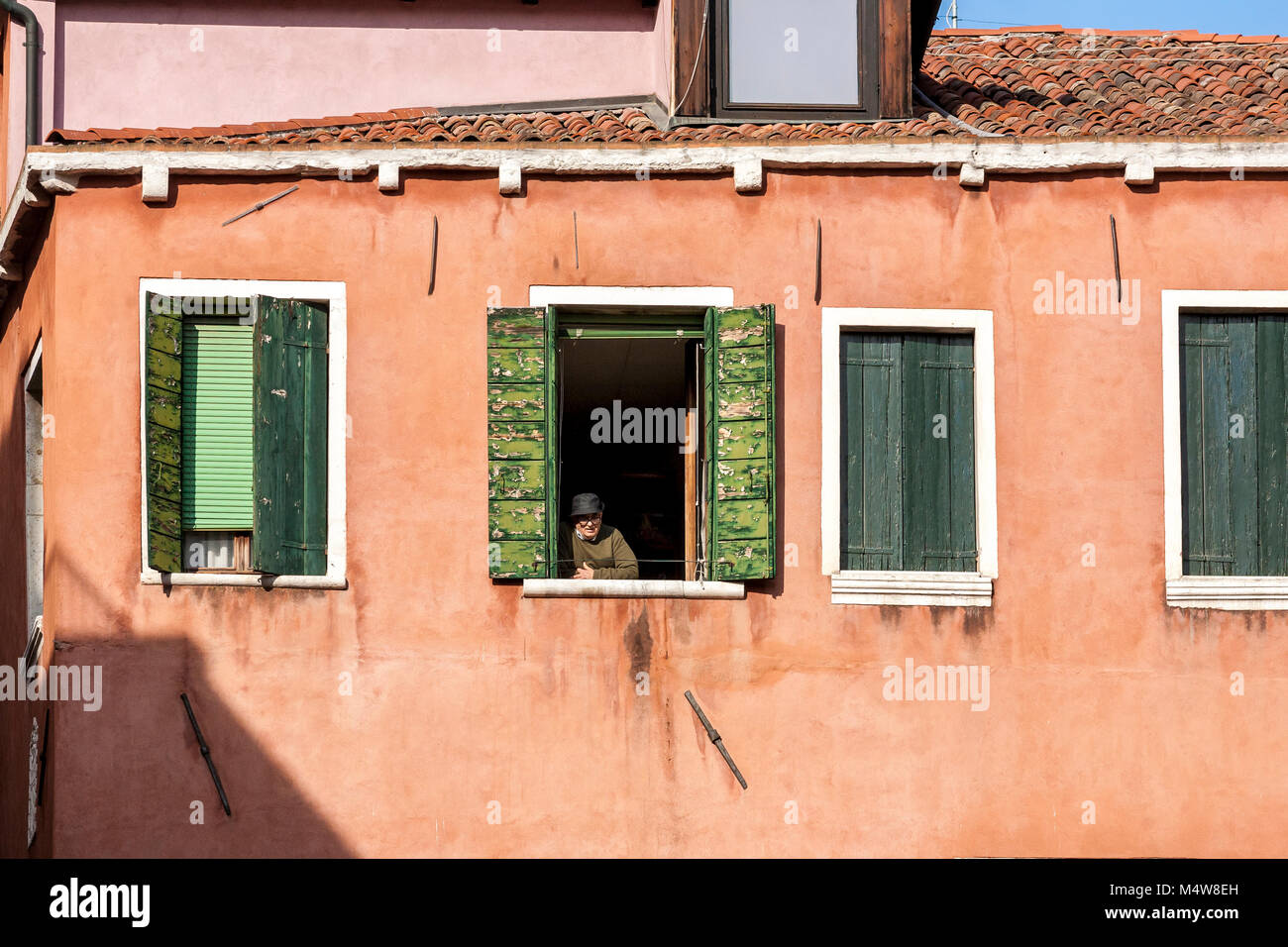 Italy, Florence. Old man looking through the window in ancient Italian ...