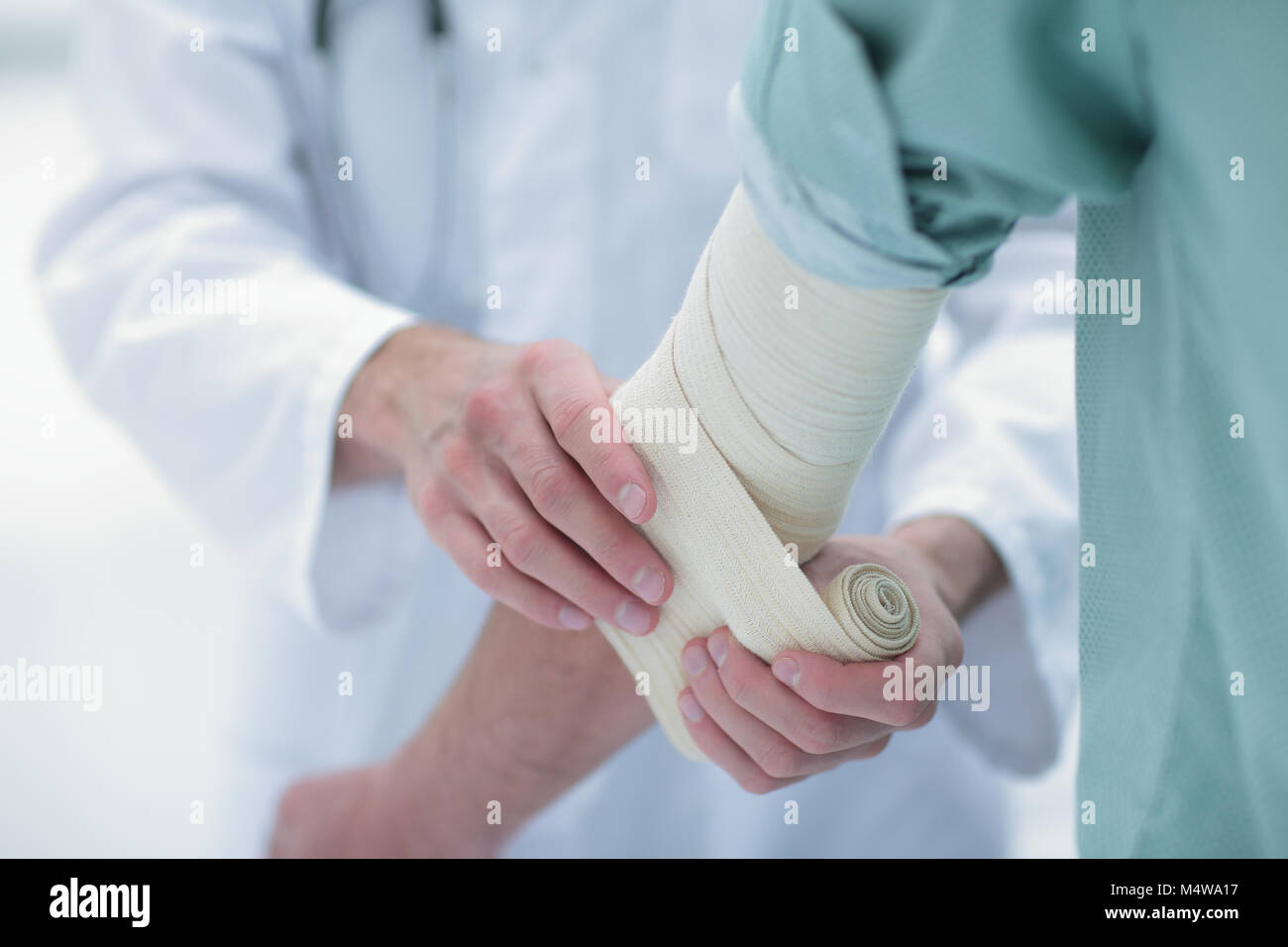 doctor applying elastic bandage on the elbow of the patient Stock Photo ...