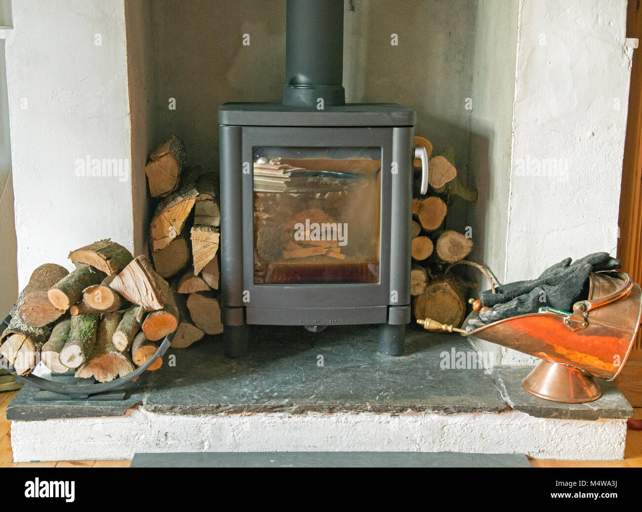 Cottage wood burning stove with logs and copper coal scuttle Stock ...