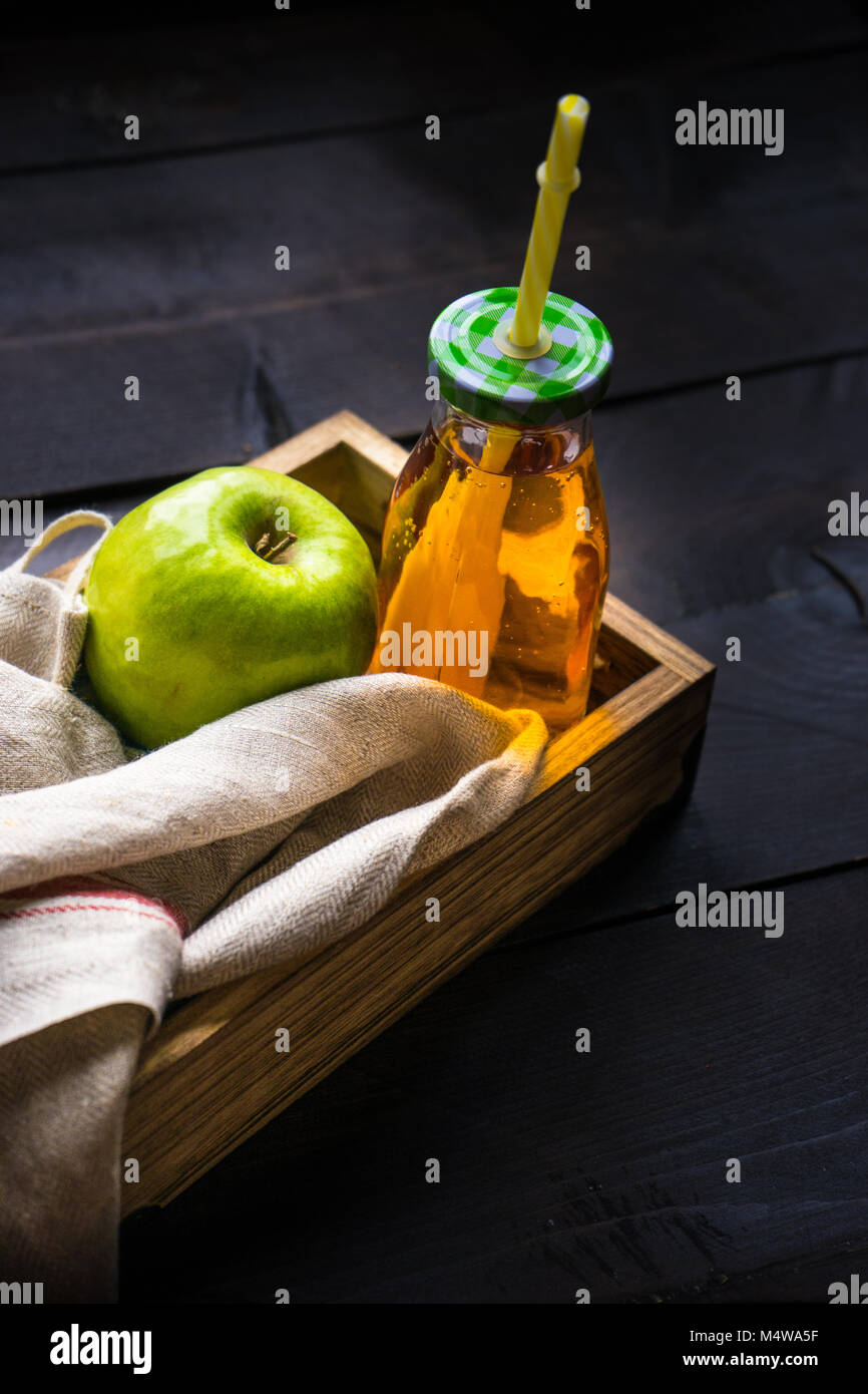 Wooden rustic box with vintage bottles of organic fruit juice on dark ...