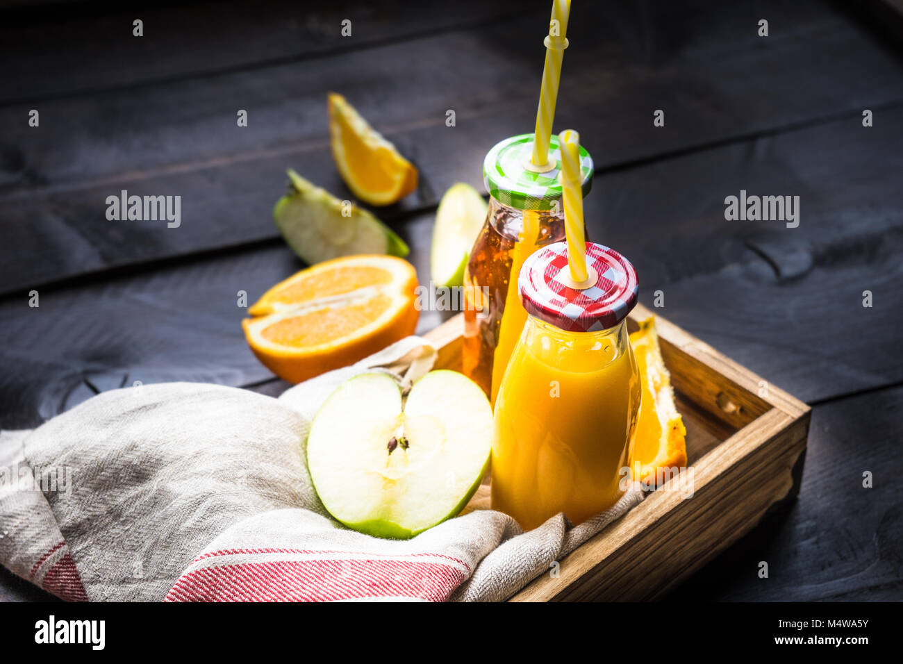 Wooden rustic box with vintage bottles of organic fruit juice on dark ...