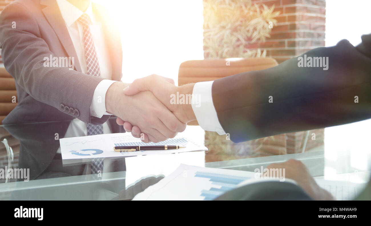 financial partners handshake after signing contract Stock Photo - Alamy