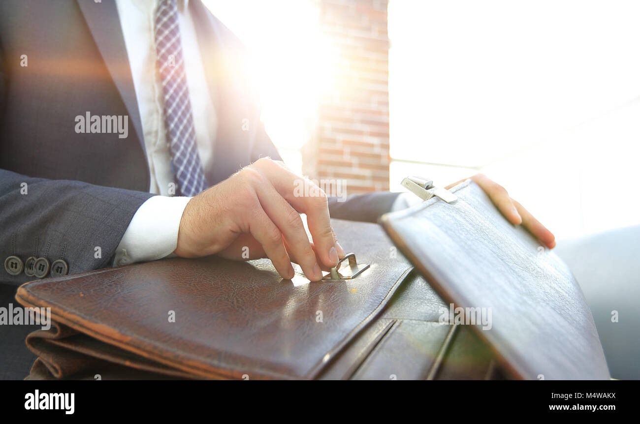 businessman's hand with suitecase in a modern office Stock Photo - Alamy