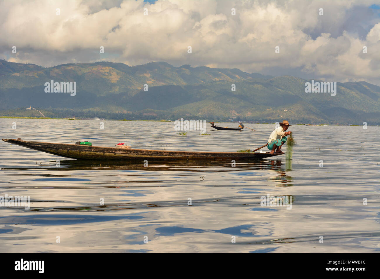 Nyaung Shwe: fisherman at Inle Lake, fishing net, leg rowing style ...