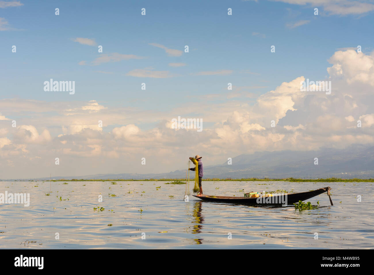 Nyaung Shwe: fisherman at Inle Lake, fishing net, leg rowing style ...