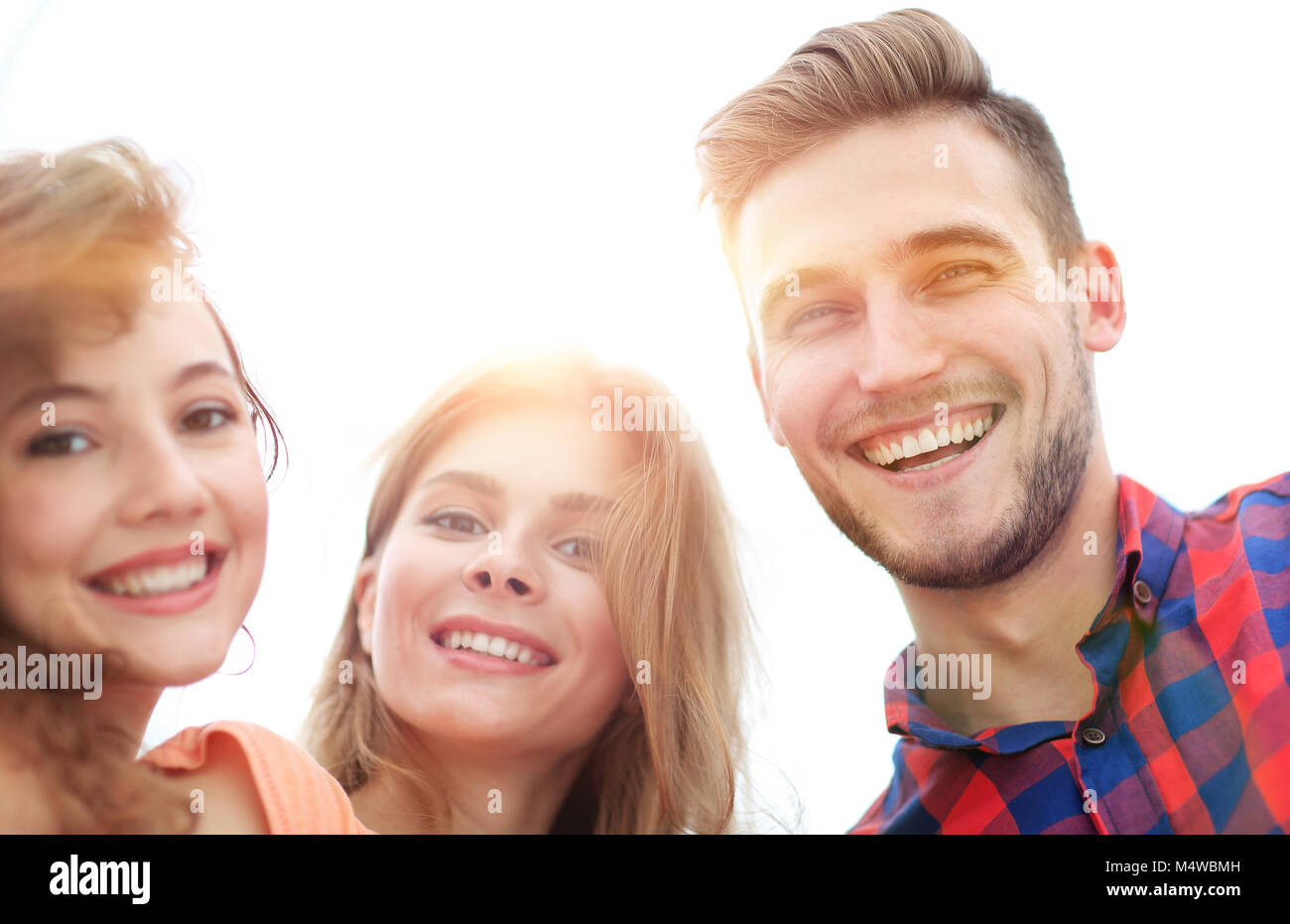 closeup of three young people smiling on white background Stock Photo ...