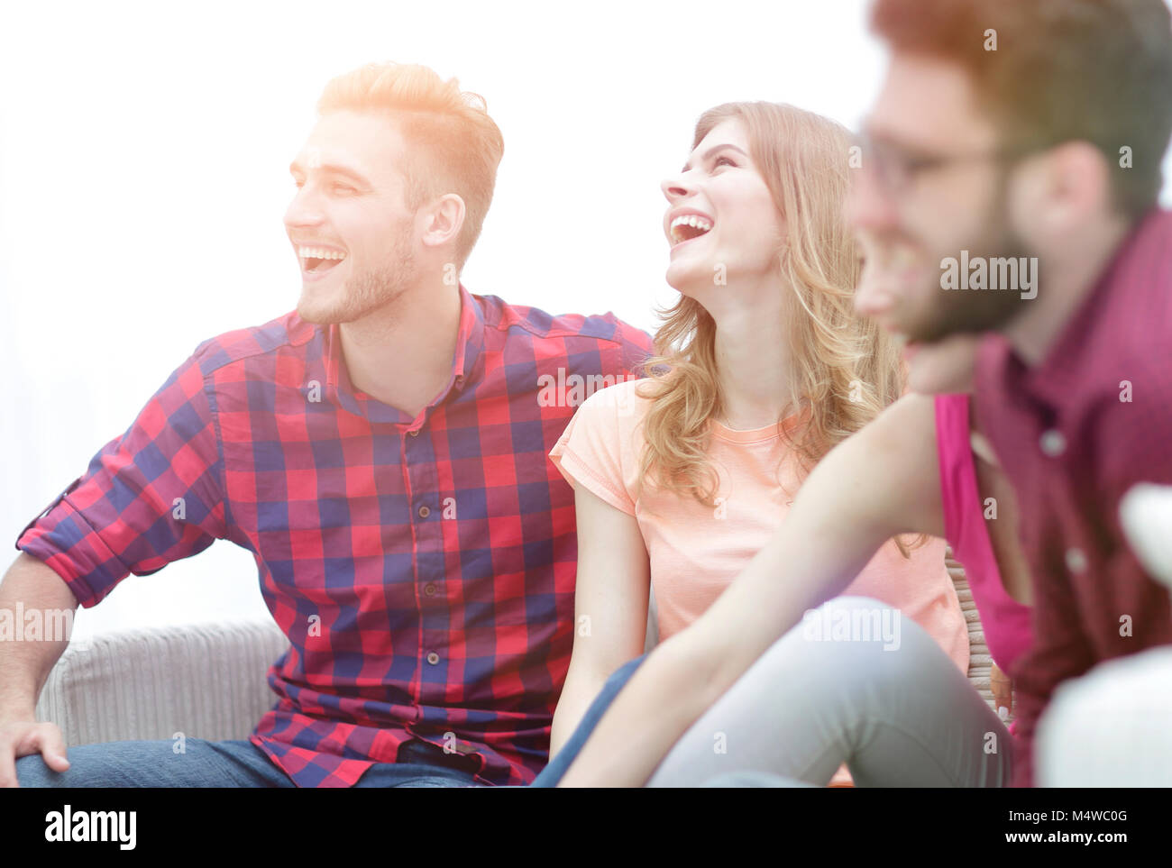 group of cheerful friends sitting on the couch Stock Photo - Alamy