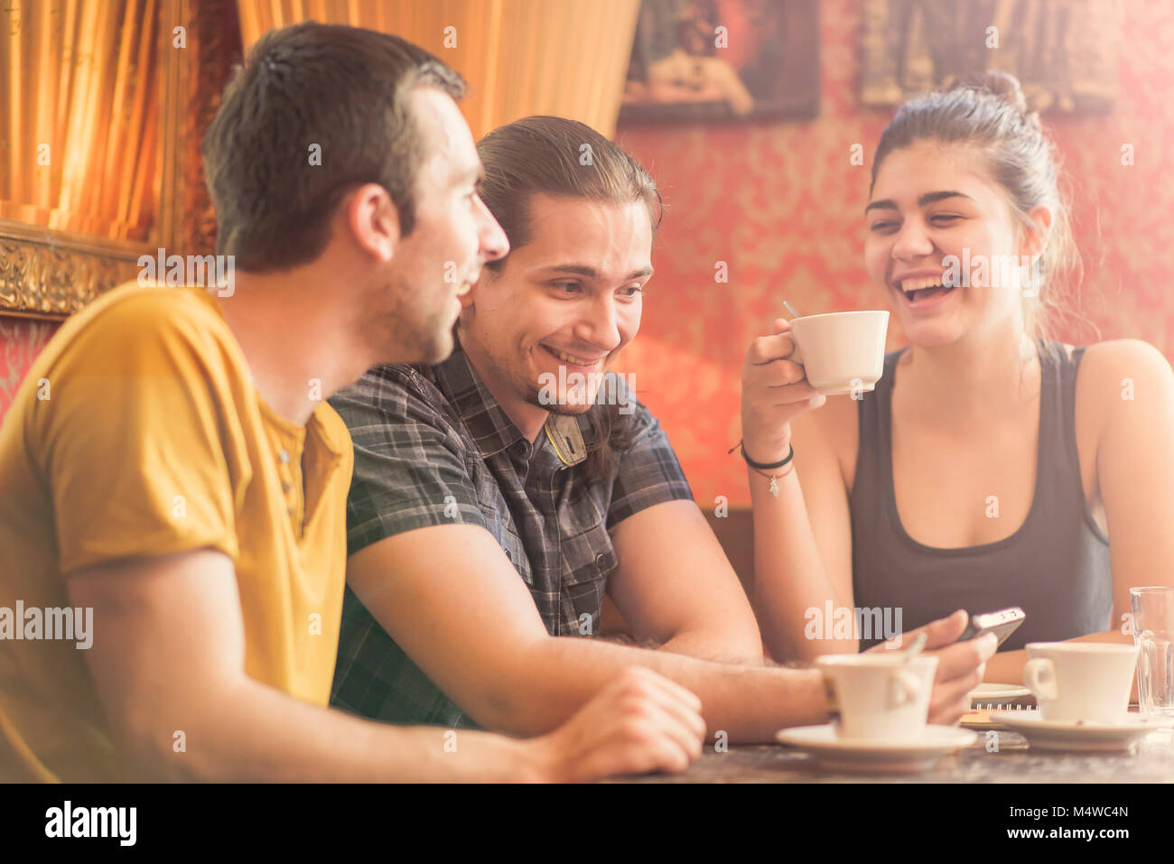 Group of three friends in a coffee shop Stock Photo - Alamy