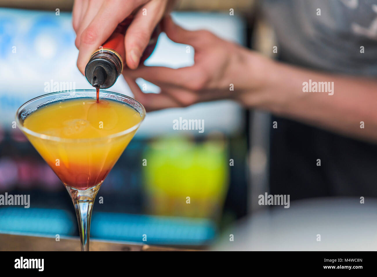 Young bartender or a waiter making a cocktail Stock Photo - Alamy