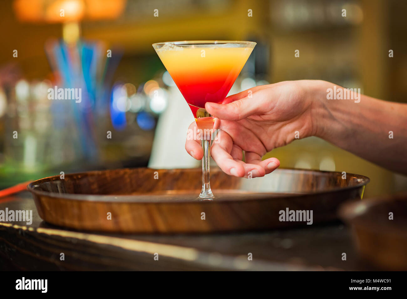 Young bartender or a waiter making a cocktail Stock Photo - Alamy