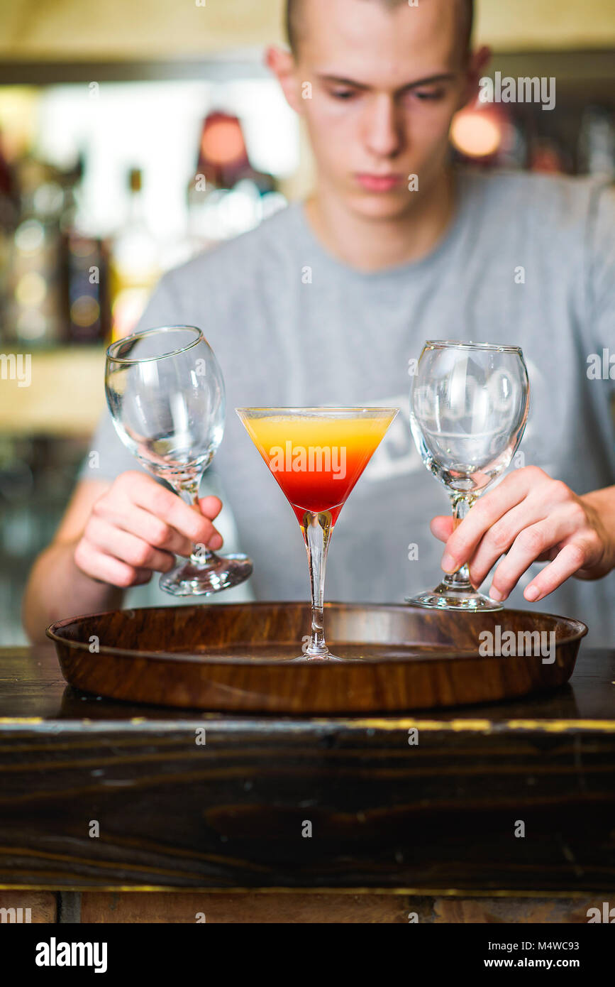 Young bartender or a waiter making a cocktail Stock Photo - Alamy