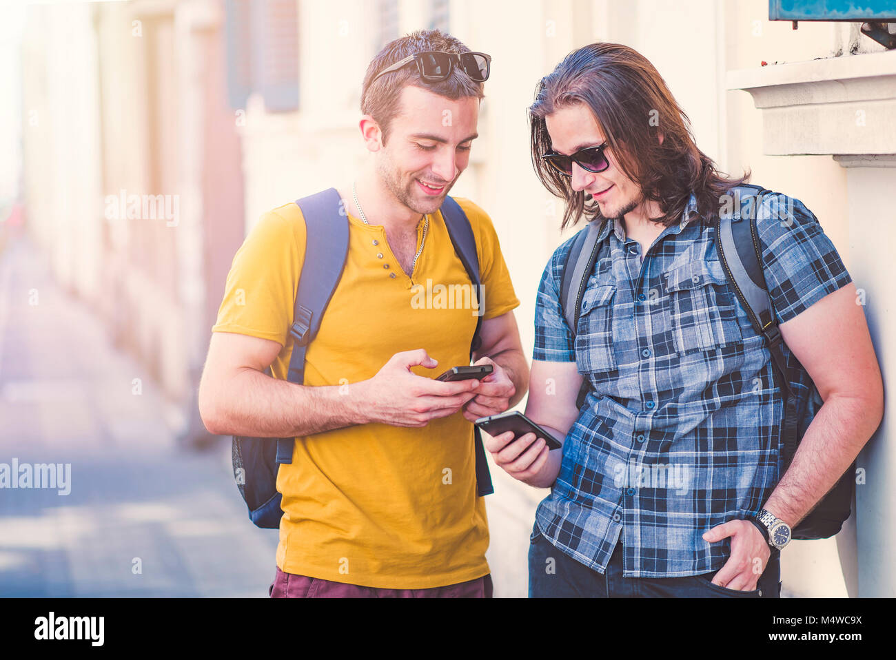 Two young man, close friends comparing phones Stock Photo - Alamy