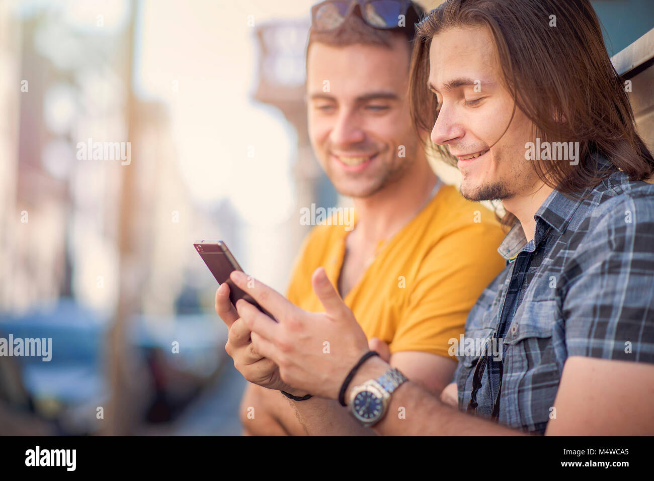 Two young man, close friends comparing phones Stock Photo - Alamy