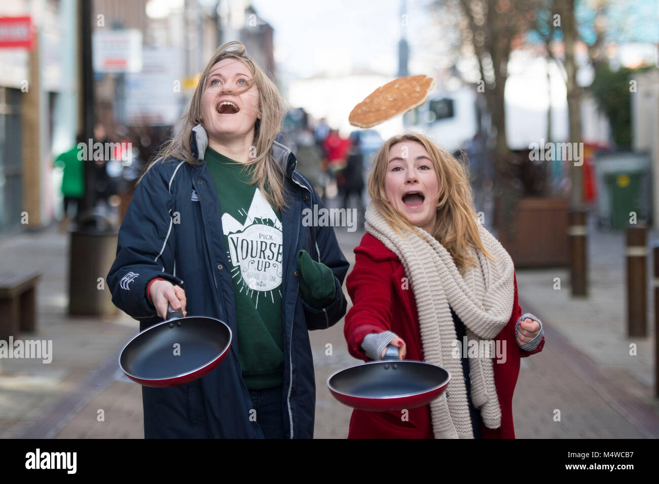 Two women girls in their twenties flip pancakes from a frying pan on ...