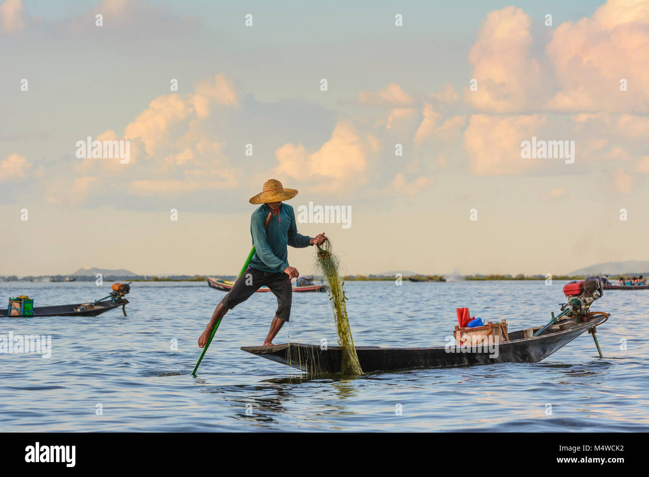 Nyaung Shwe: fisherman at Inle Lake, fishing net, leg rowing style ...