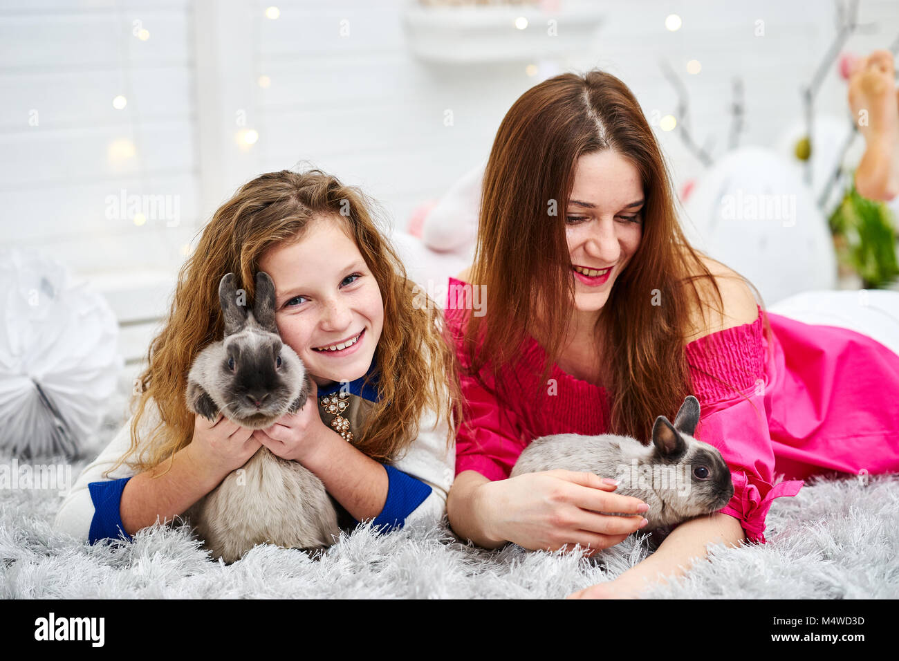 Little girl and young woman with rabbits Stock Photo - Alamy