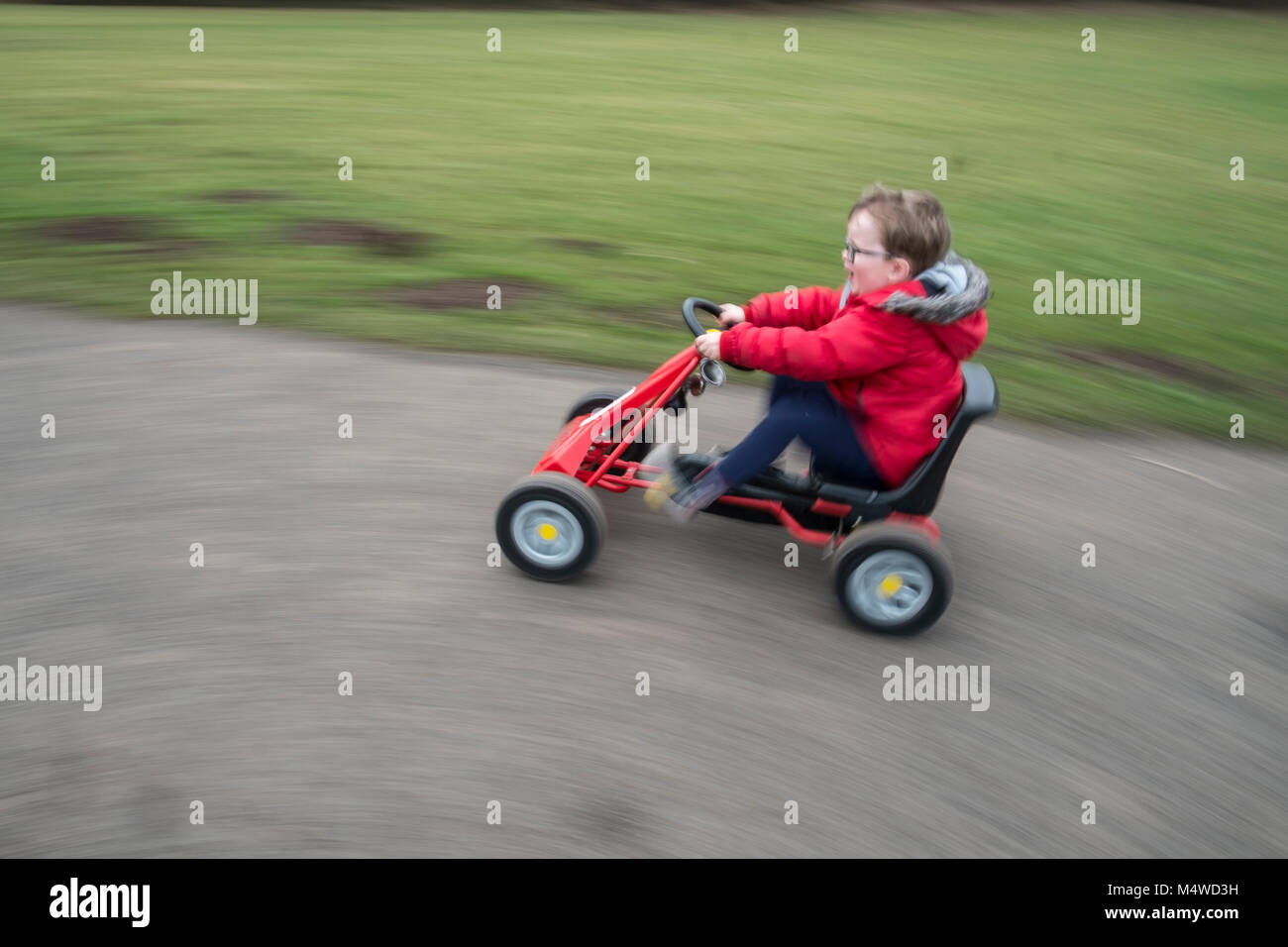 A young boy playing on his red pedal Go-Kart Stock Photo - Alamy