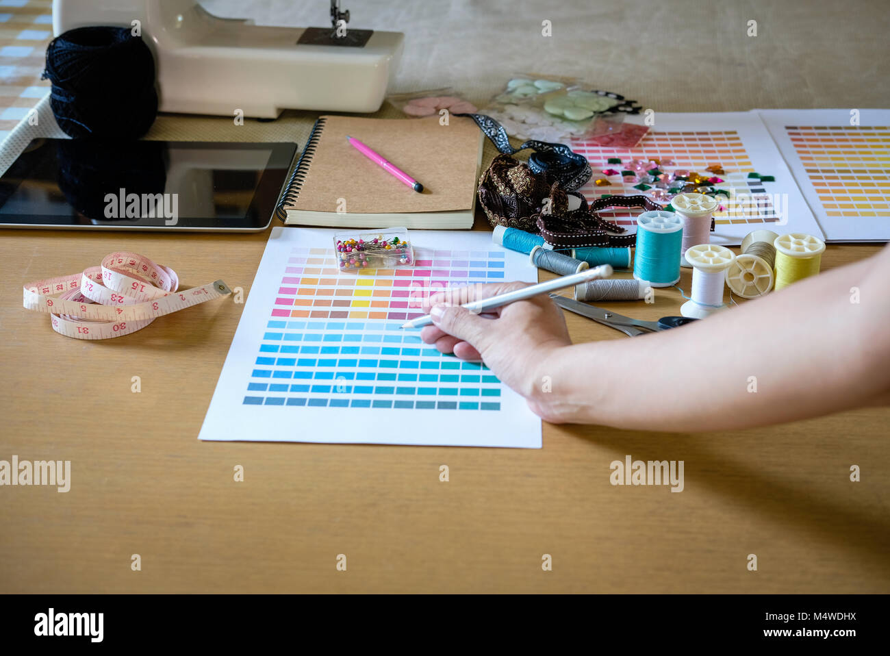 equipment on fashion designer working in studio with equipment on desk ...