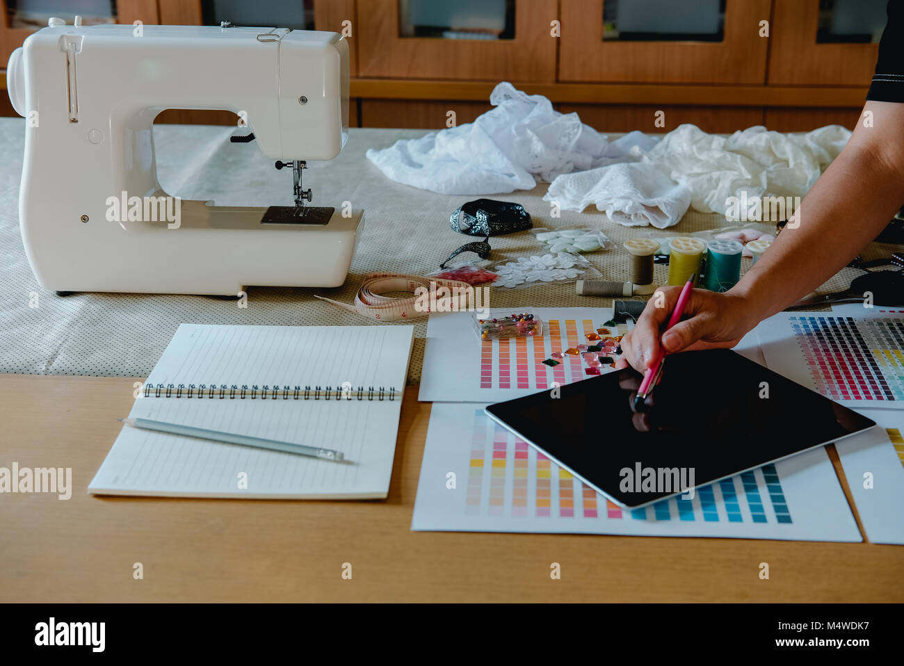 equipment on fashion designer working in studio with equipment on desk ...