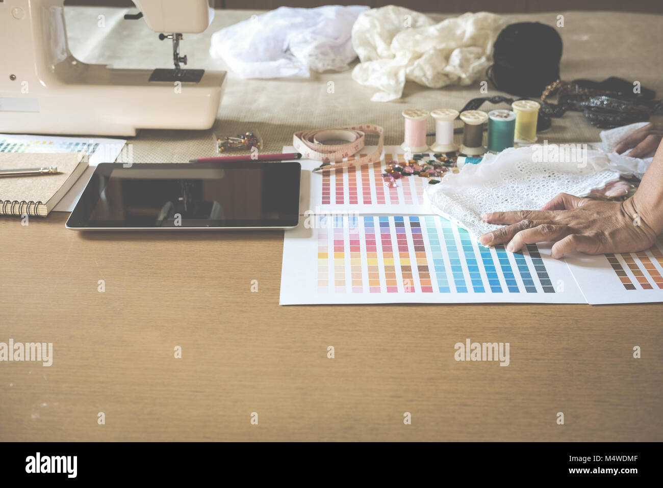 equipment on fashion designer working in studio with equipment on desk ...