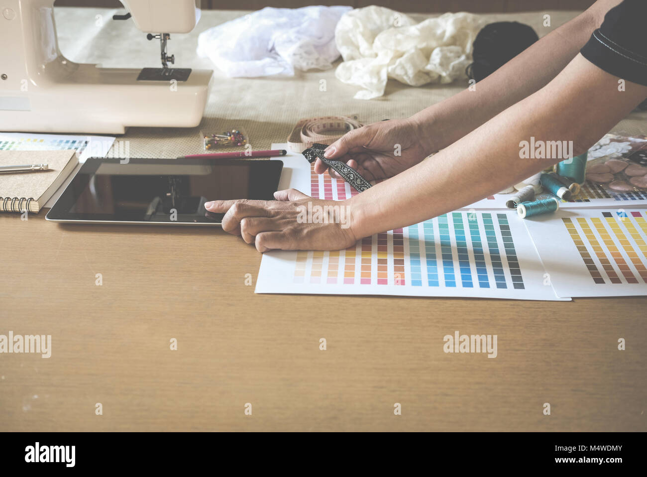 equipment on fashion designer working in studio with equipment on desk ...