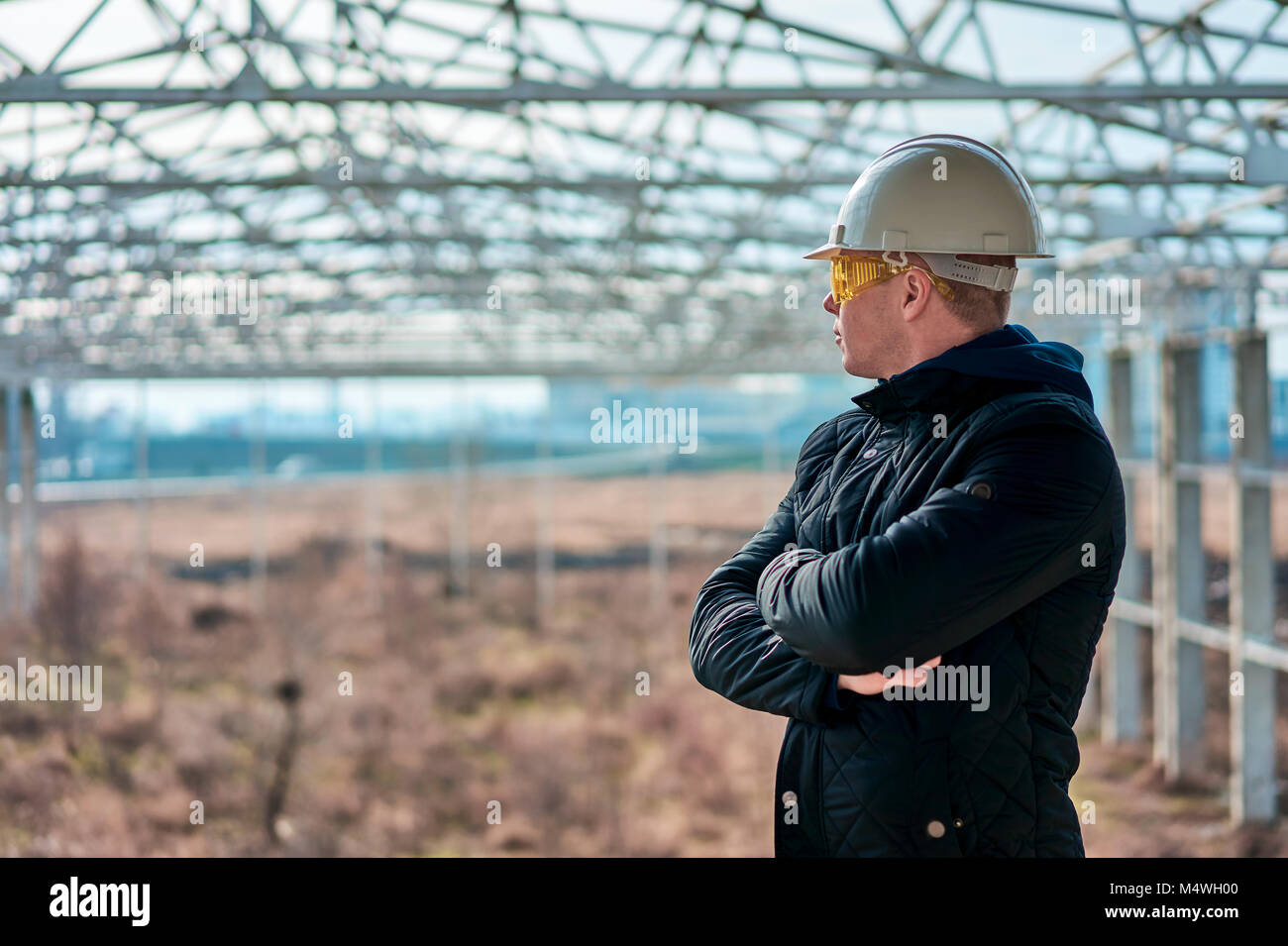 Builder in a helmet on construction object Stock Photo - Alamy