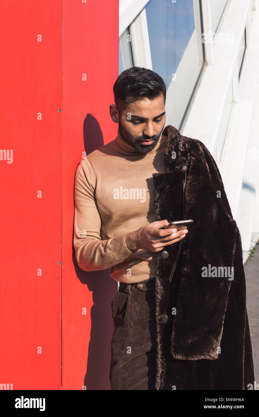 Handsome Indian man texting in an urban context. Street fashion and ...